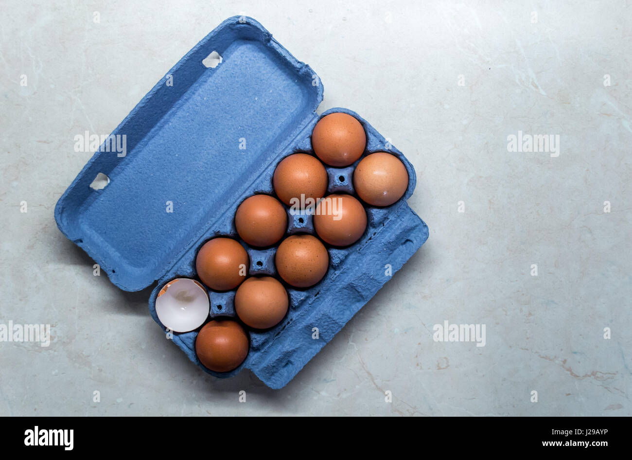 Nine Eggs in a Blue Egg Box/Carton with One Broken on Kitchen Counter ...