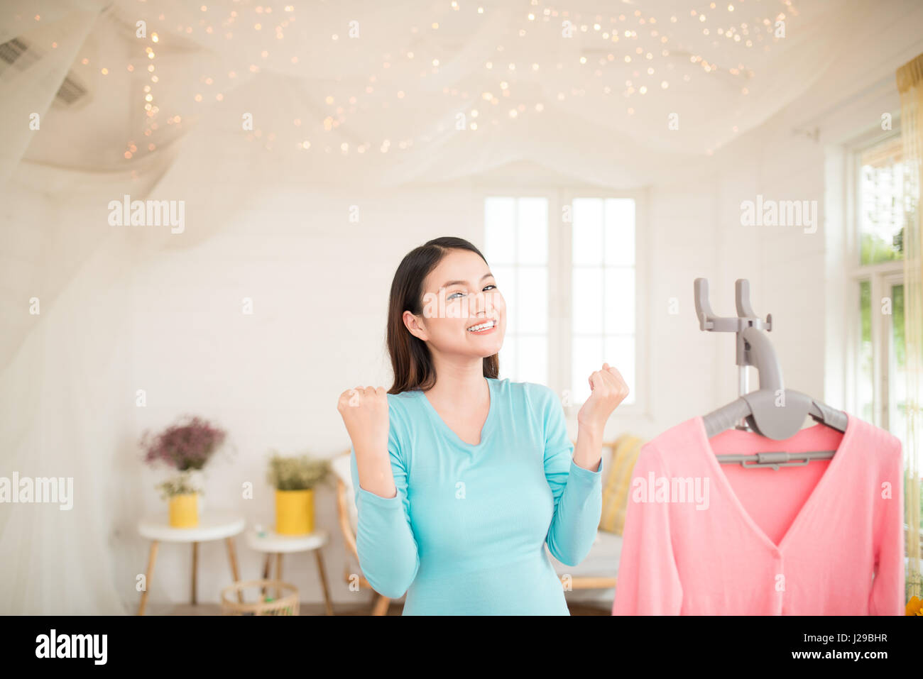 Happy young asian woman finish steaming clothes in room Stock Photo - Alamy