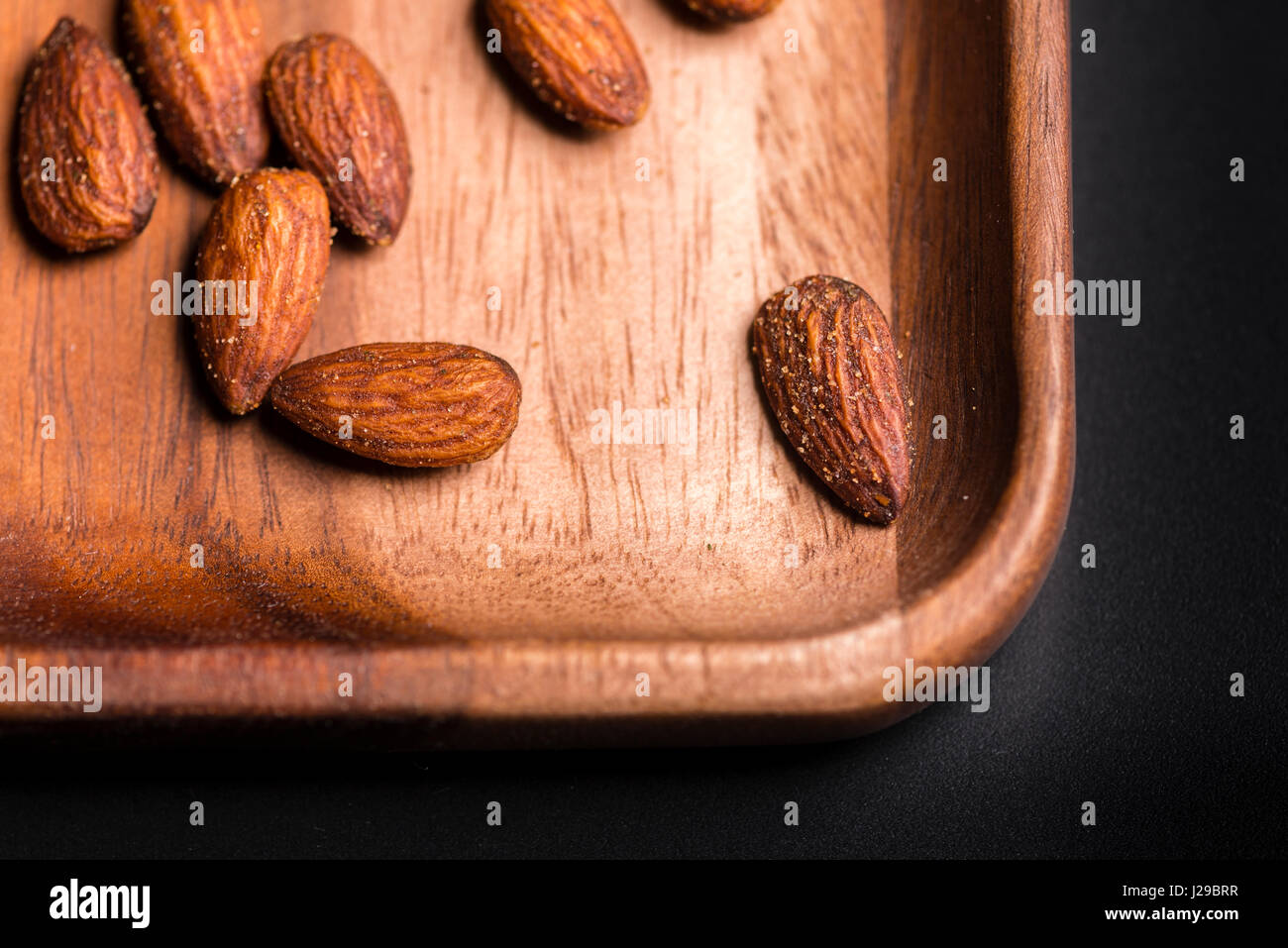 Toasted almonds in a wood sish over a black board Stock Photo - Alamy