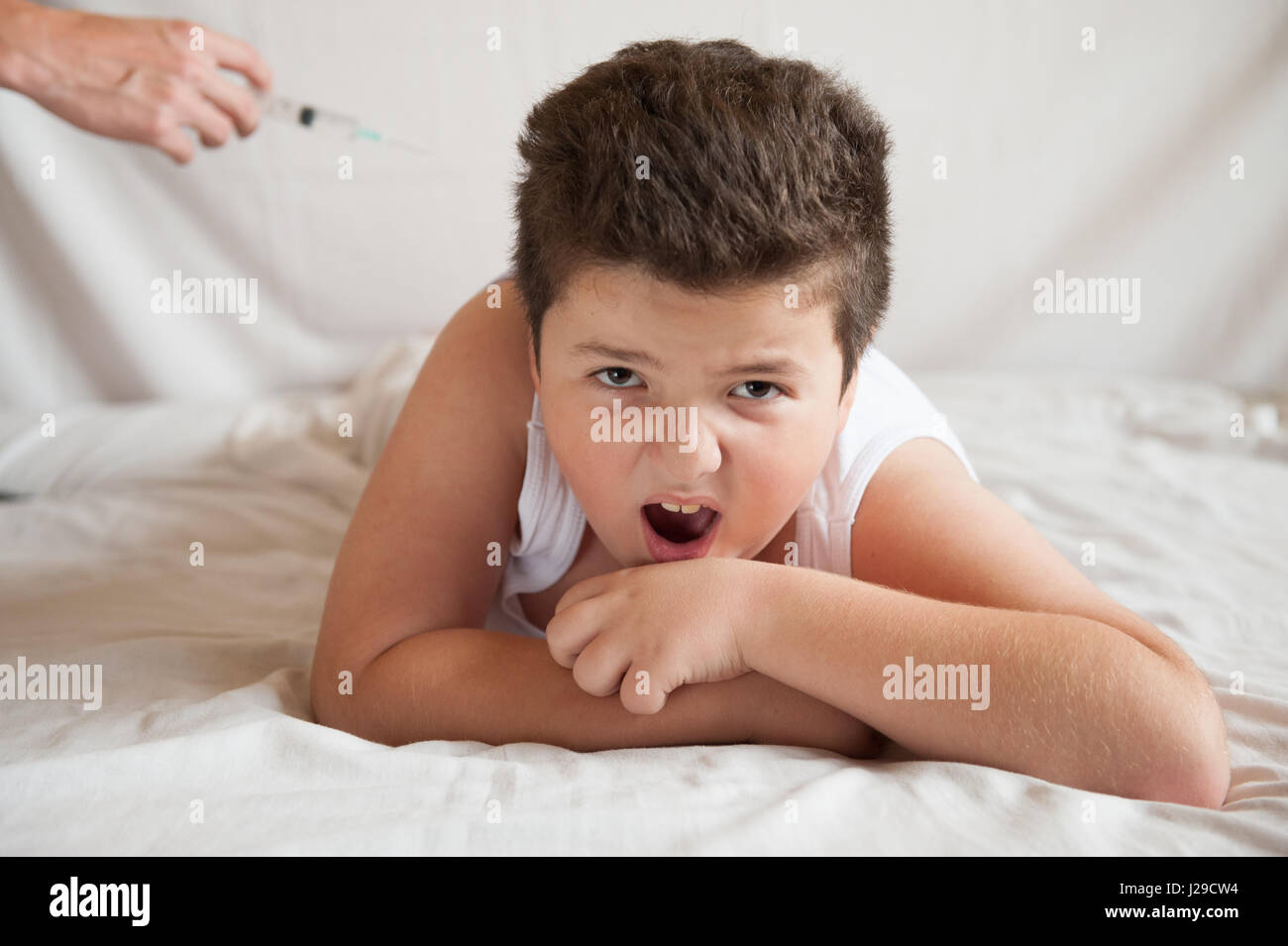 scared fat boy is afraid of the hand with a syringe and screams Stock ...