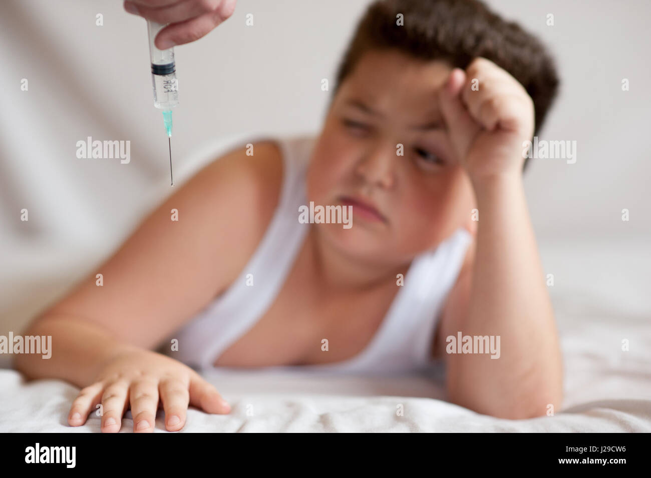 scared cute fat boy grabbed his head, frightened by the hand of doctor ...