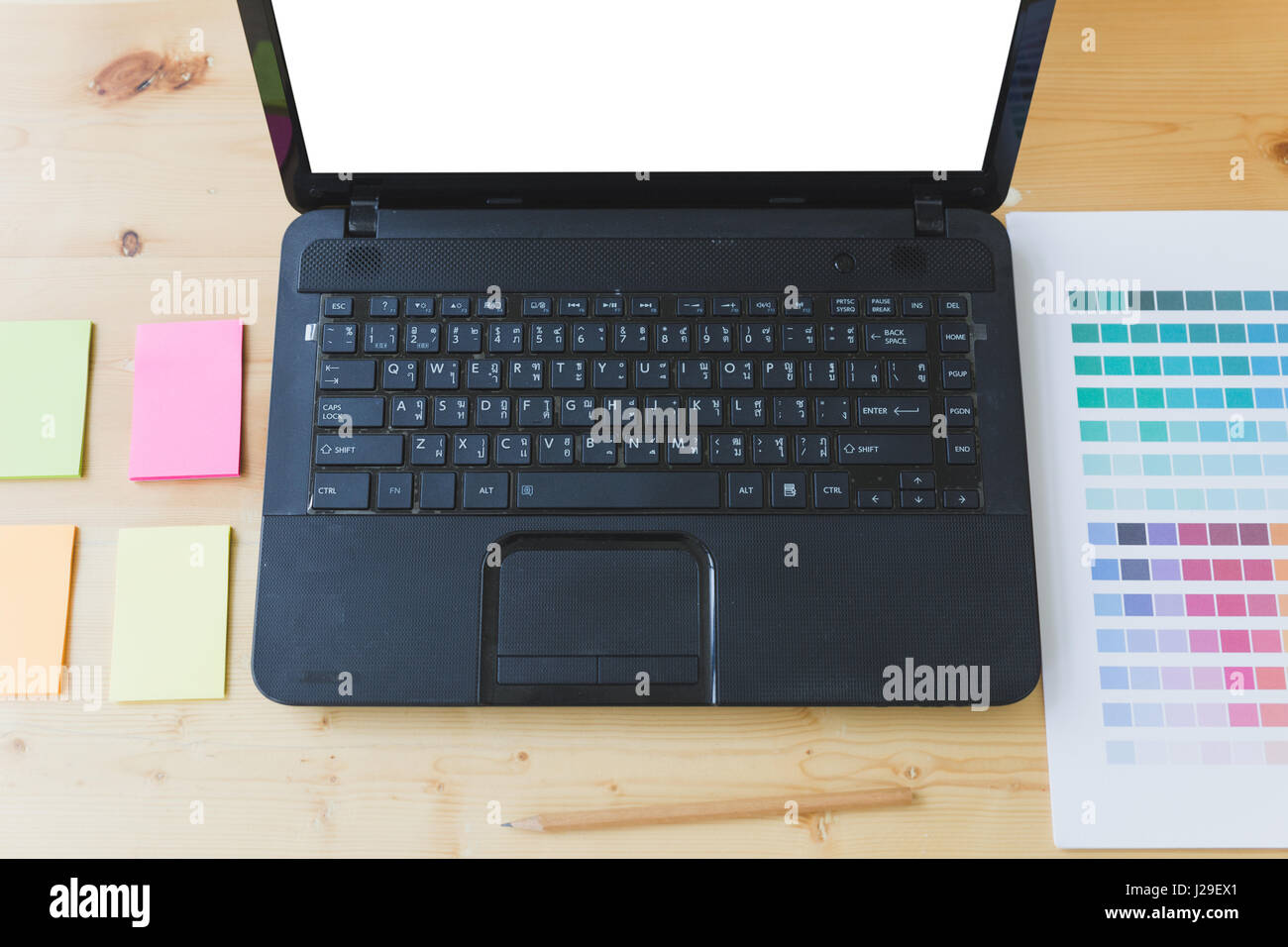 Working desk with sticky note, color guide palette swatches and laptop ...