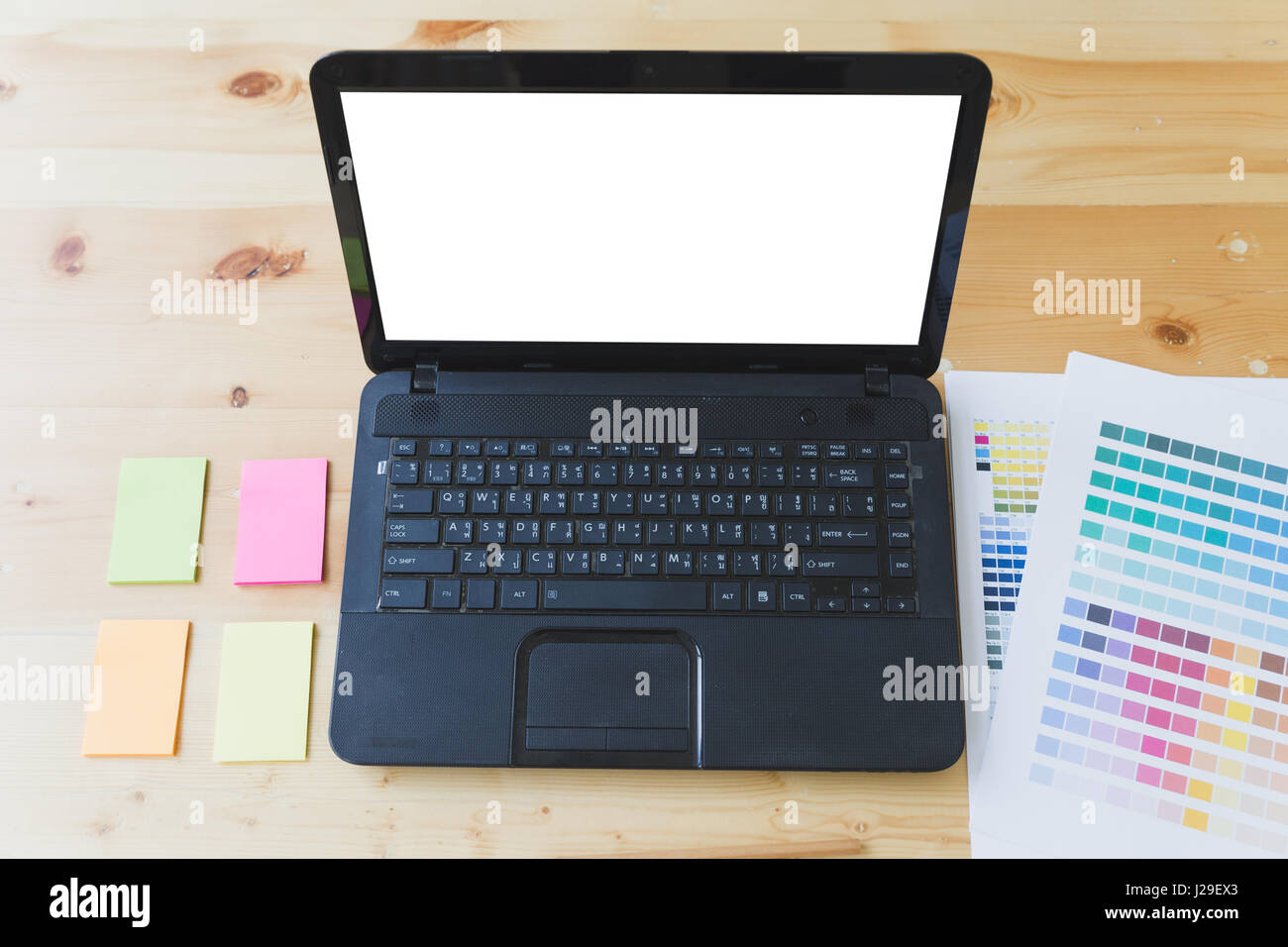Working desk with sticky note, color guide palette swatches and laptop ...