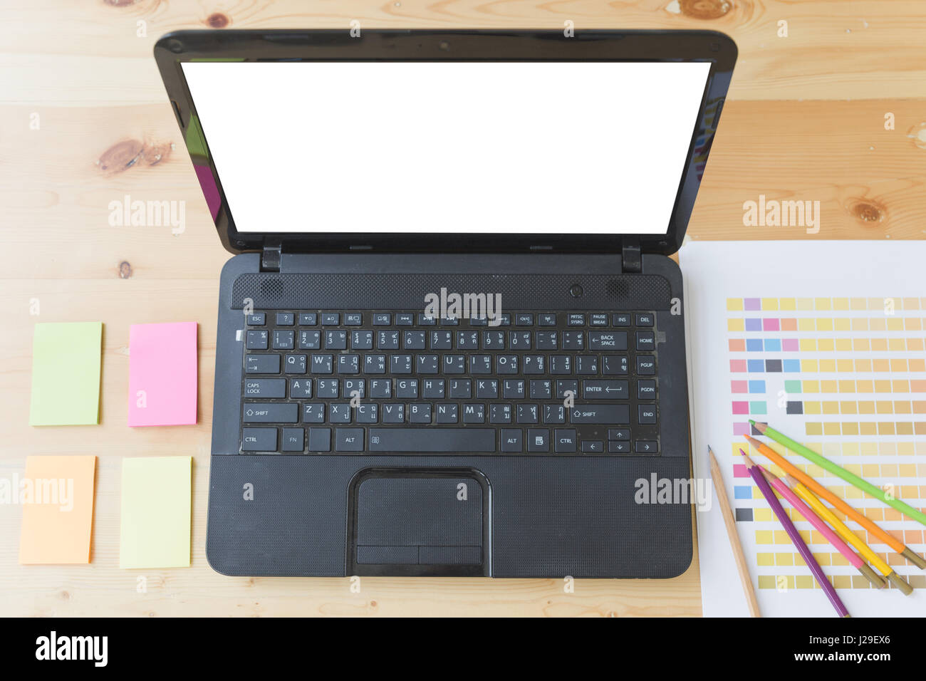 Working desk with sticky note, color guide palette swatches and laptop ...