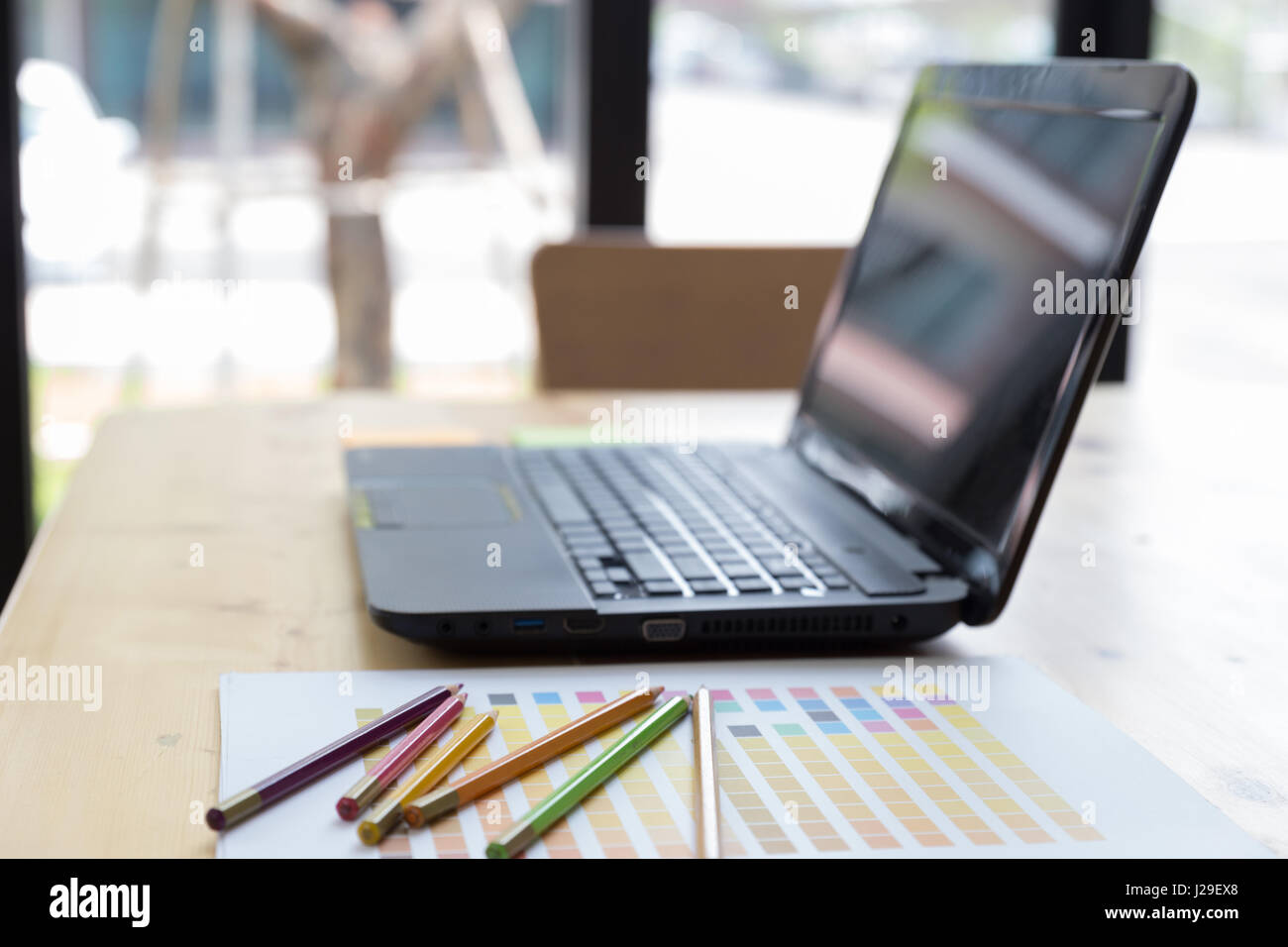Working desk with crayon, color guide palette swatches and laptop ...