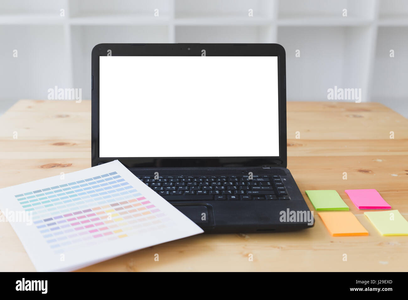 Working desk with sticky note, color guide palette swatches and laptop ...