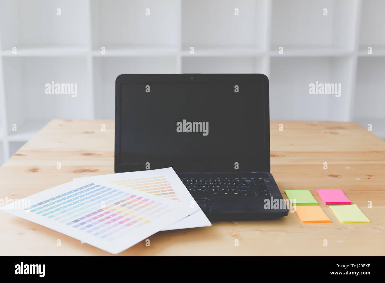 Working desk with sticky note, color guide palette swatches and laptop ...