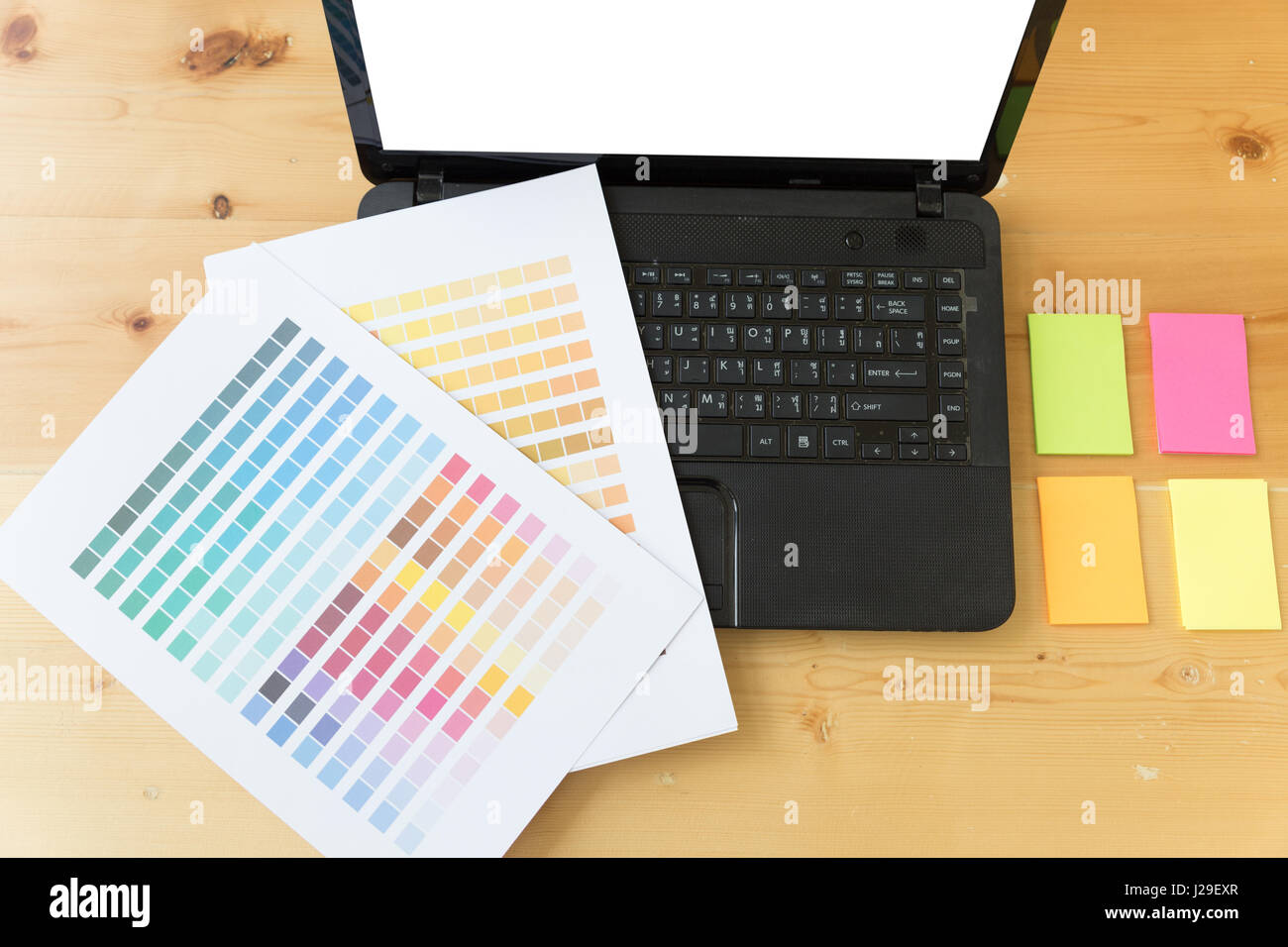 Working desk with sticky note, color guide palette swatches and laptop ...