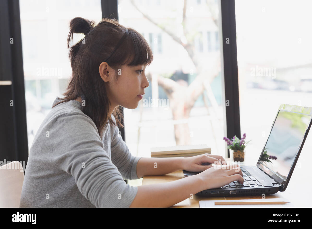 asian girl female teenager studying at school. Student typing on laptop ...