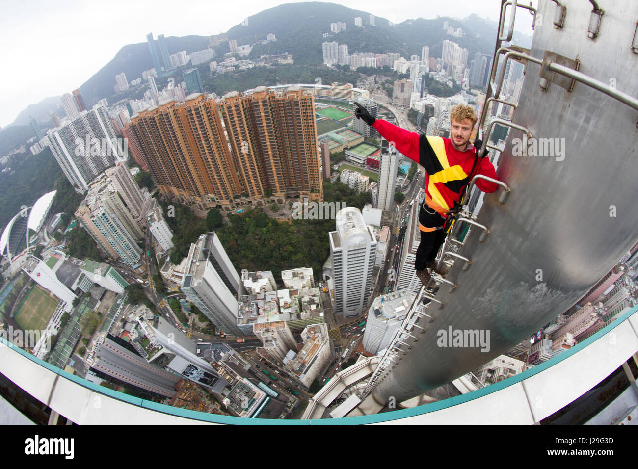 One rooftopper hangs from the side of a building. MIND-BLOWING pictures of a team of thrill ...