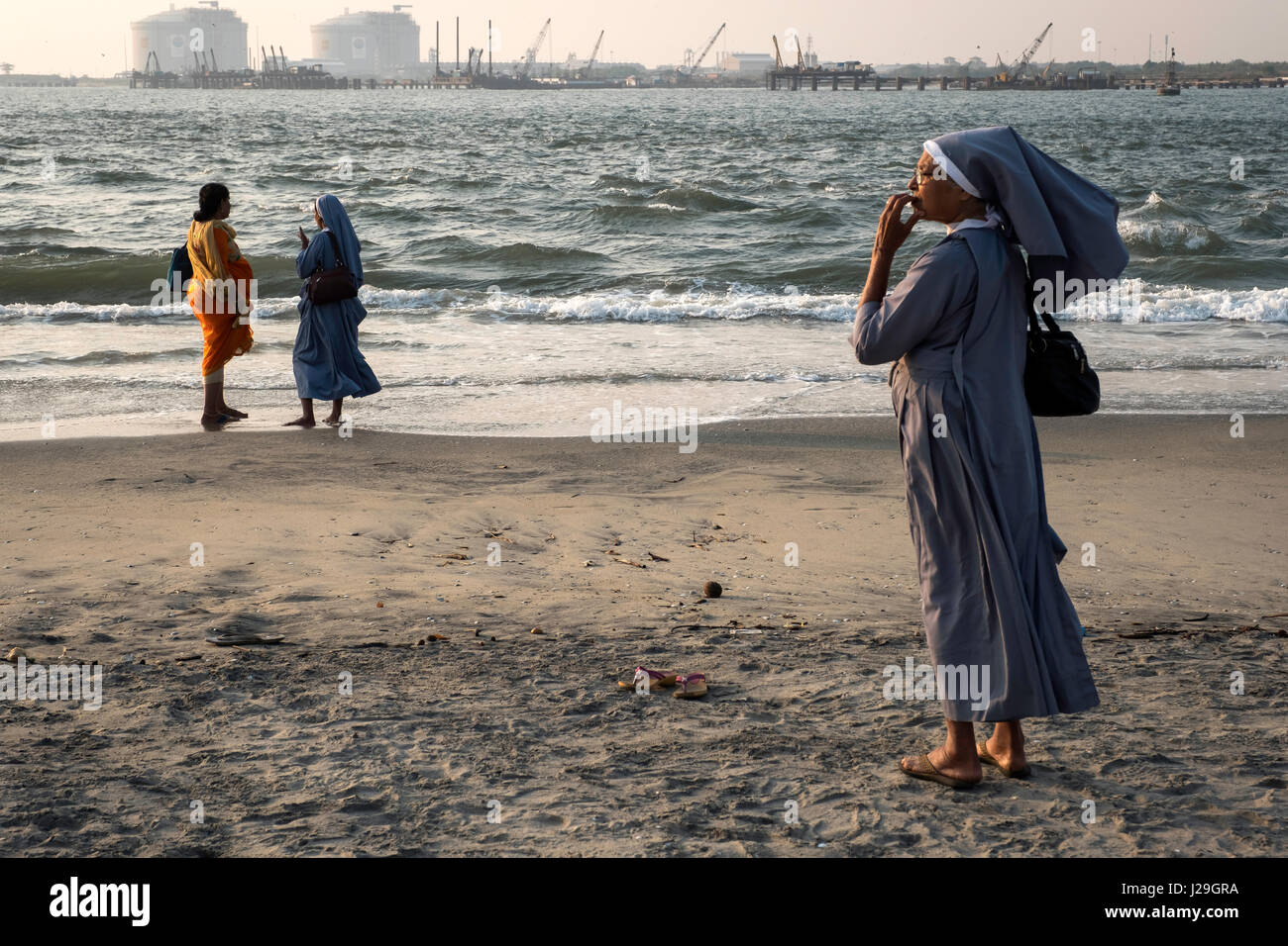 Nuns walk along the beach of the city of Kochi Stock Photo - Alamy