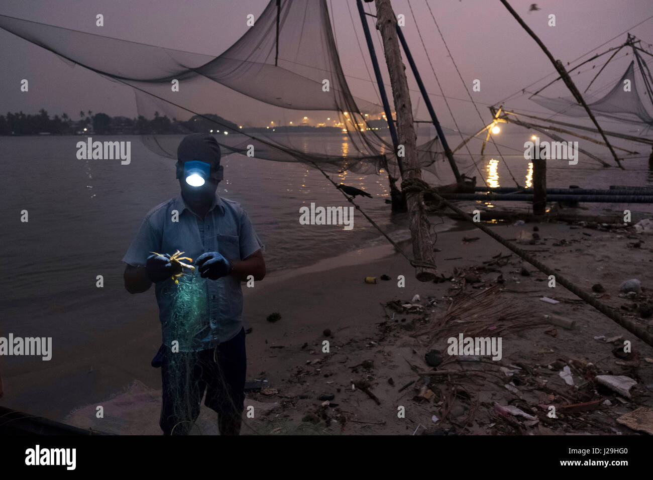 A fisherman takes out a crab trapped in the fishing net Stock Photo - Alamy