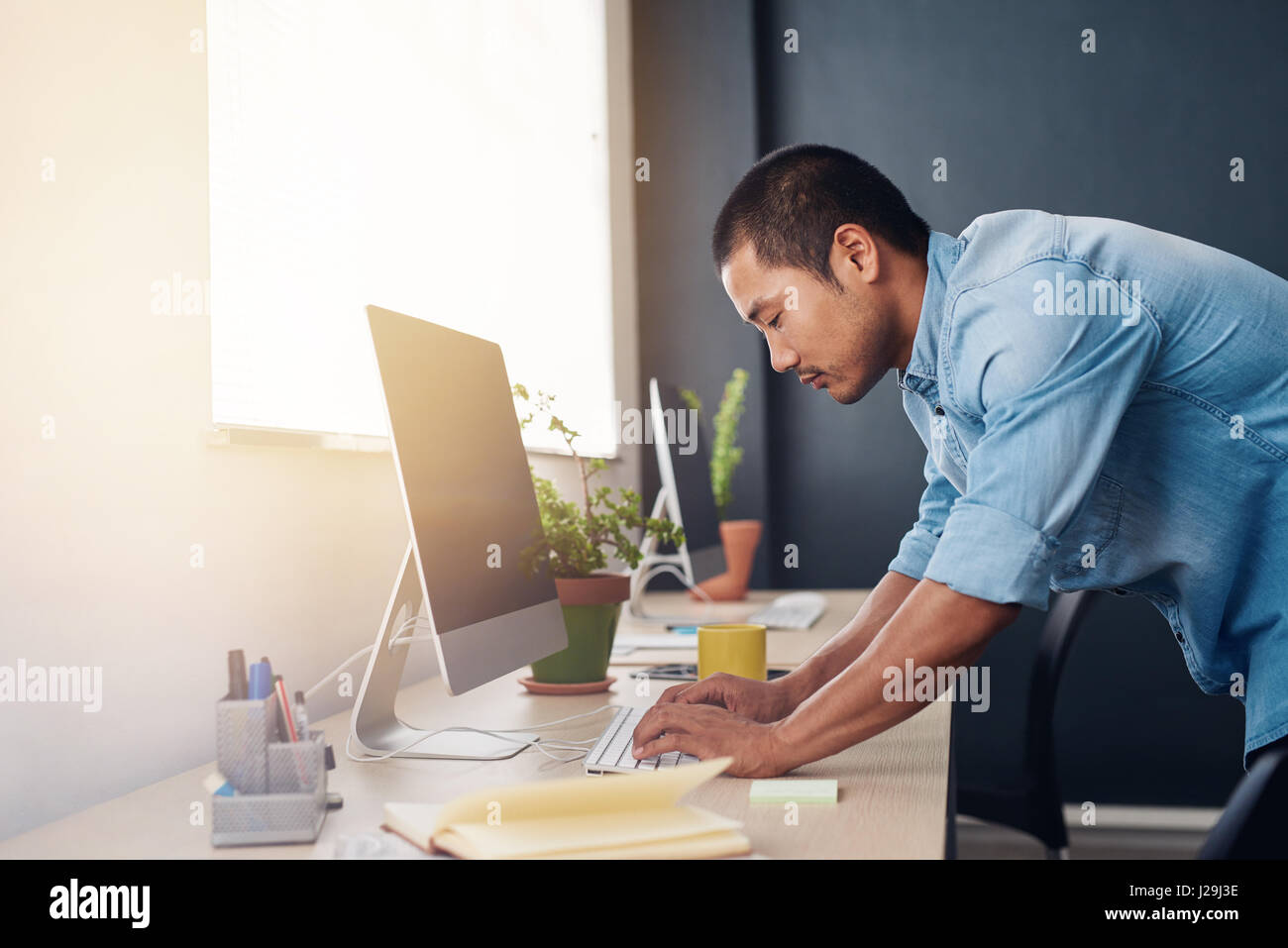 Business a man standing over a desk hi-res stock photography and images ...
