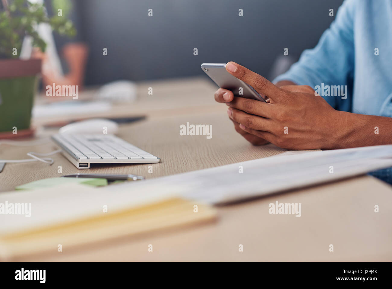 Young designer reading text messages at his office desk Stock Photo - Alamy
