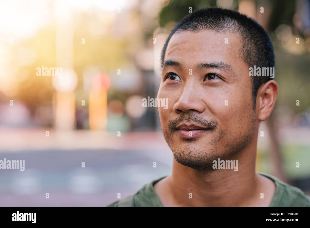 Handsome young Asian man standing on a city street Stock Photo - Alamy