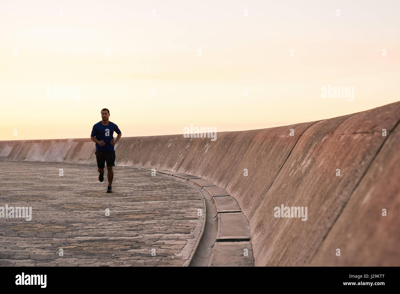 Athletic young Asian man running on a morning run Stock Photo - Alamy
