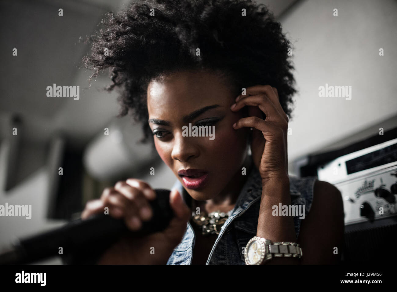 Young singer performing in a studio Stock Photo - Alamy