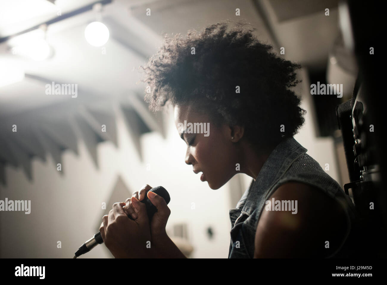 Young singer performing in a studio Stock Photo - Alamy