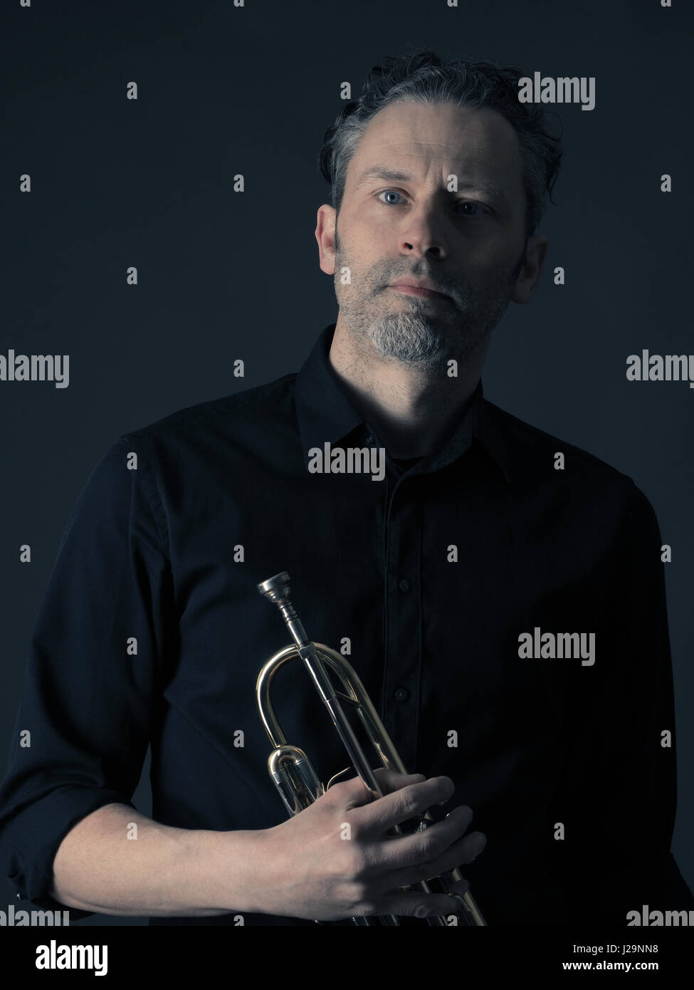 Dark portrait of a musician with a brass instrument Stock Photo - Alamy