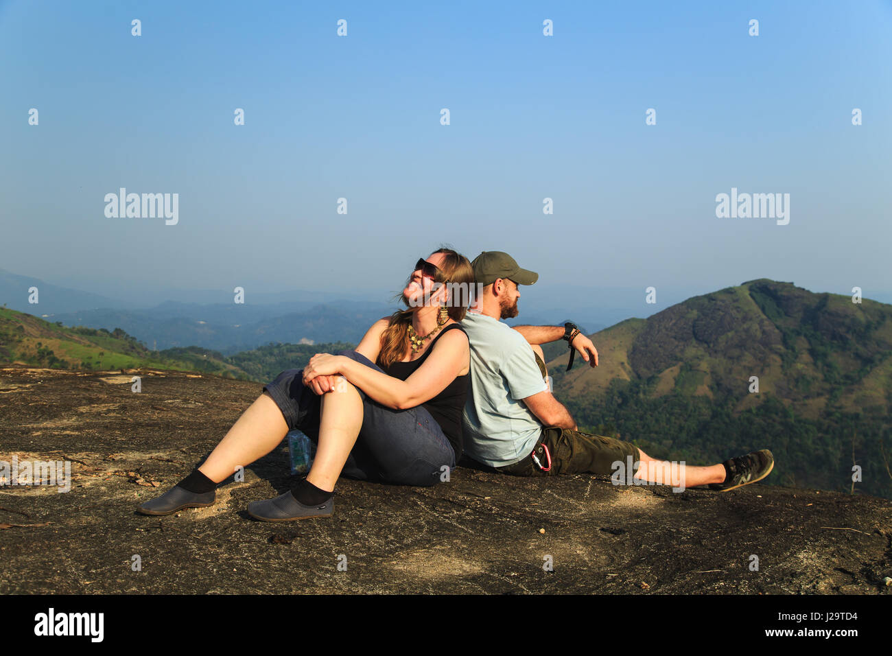 Group of tourists watching the sunset on top of the mountain. Rest ...