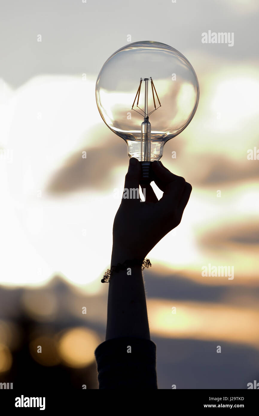 Energy light bulb from sunset on hand concept Stock Photo - Alamy