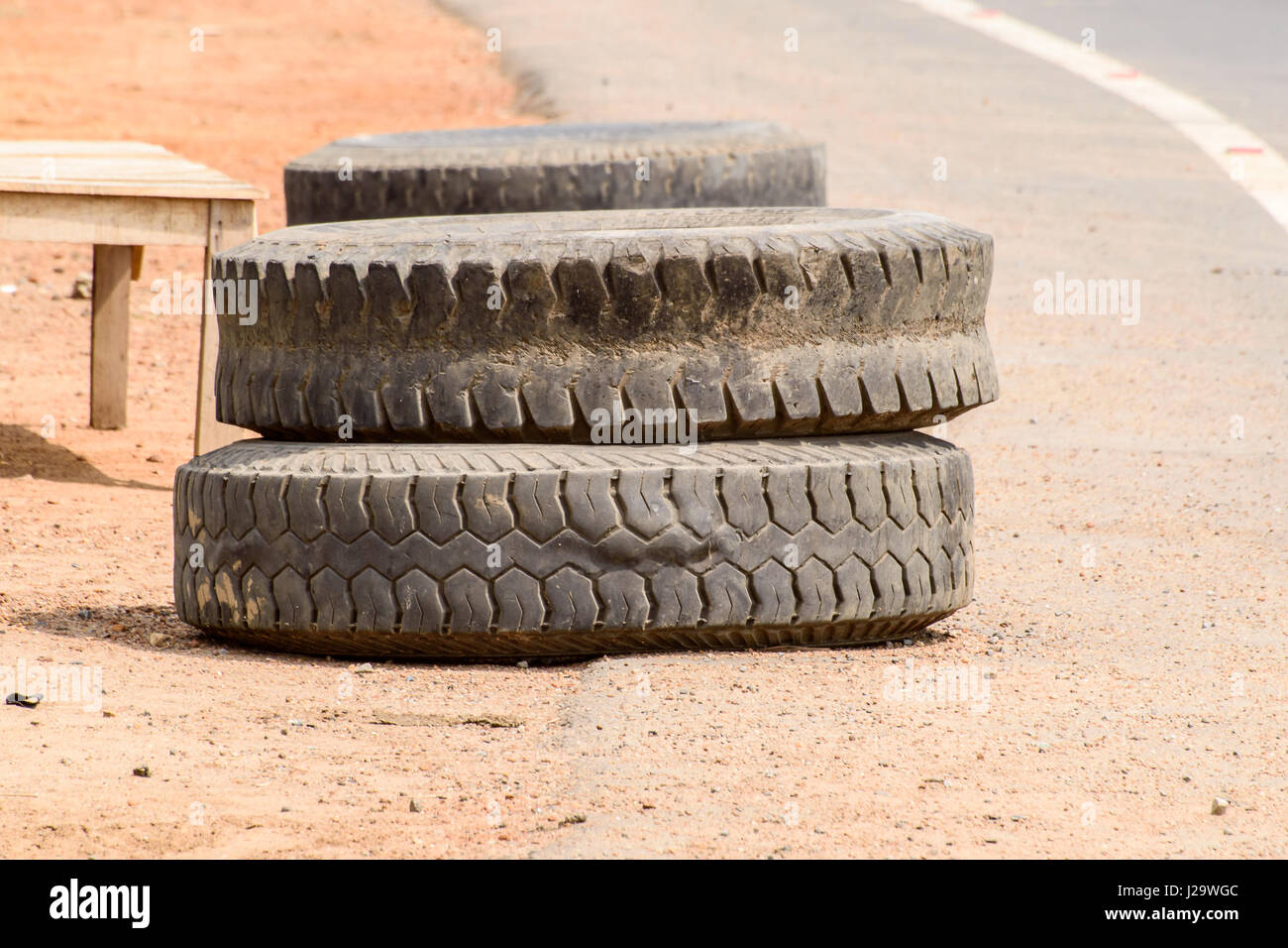 two old rotten rubber tires on the side of a road with blurry ...