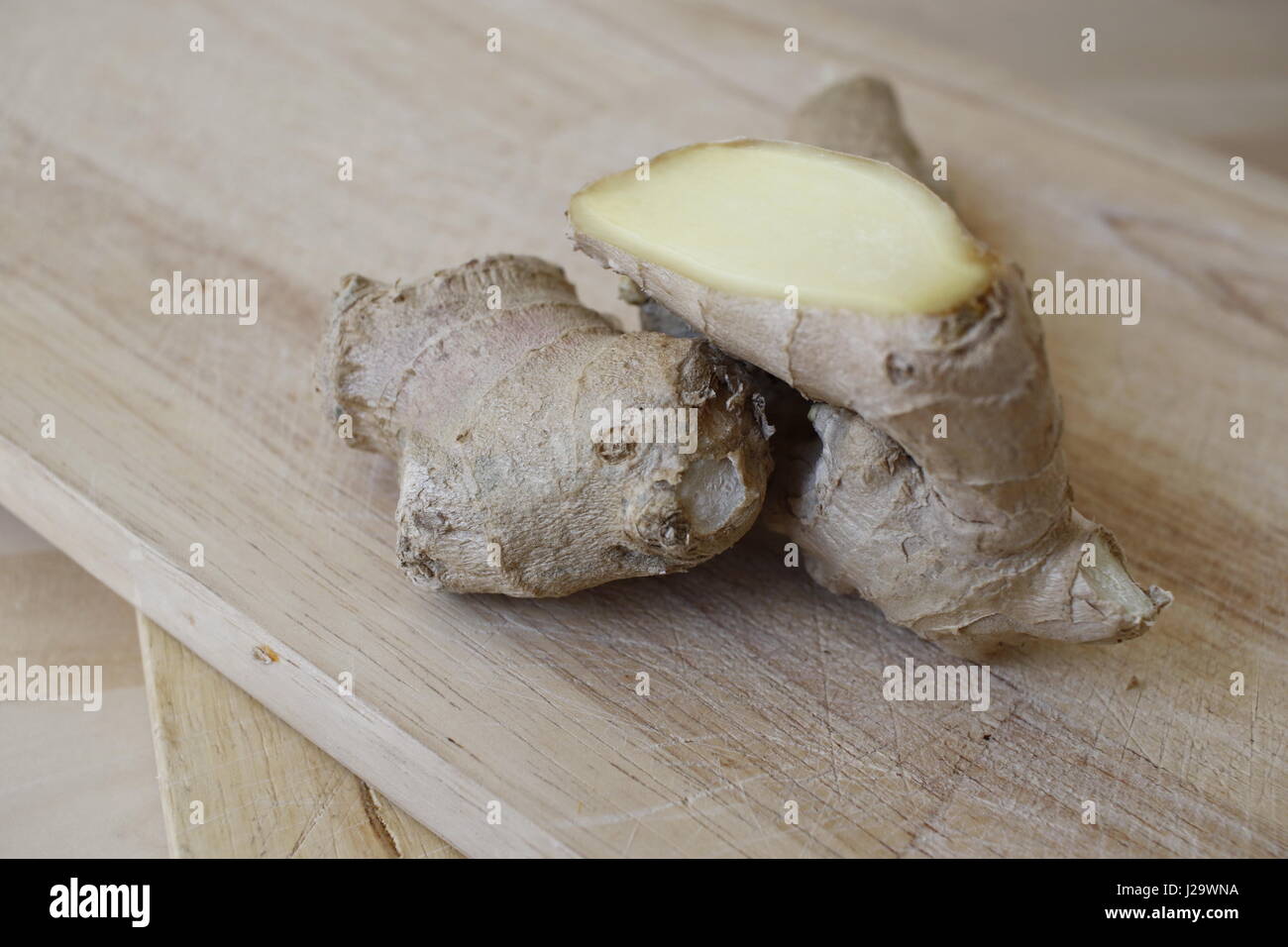 Pieces of ginger root on a wooden plate Stock Photo - Alamy