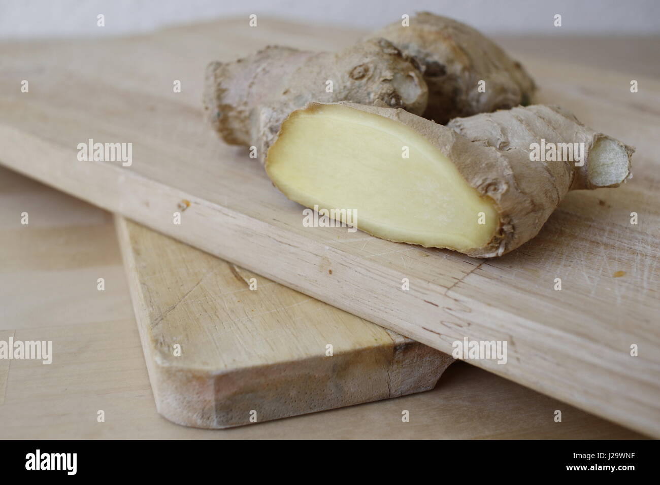 Pieces of ginger root on a wooden plate Stock Photo - Alamy