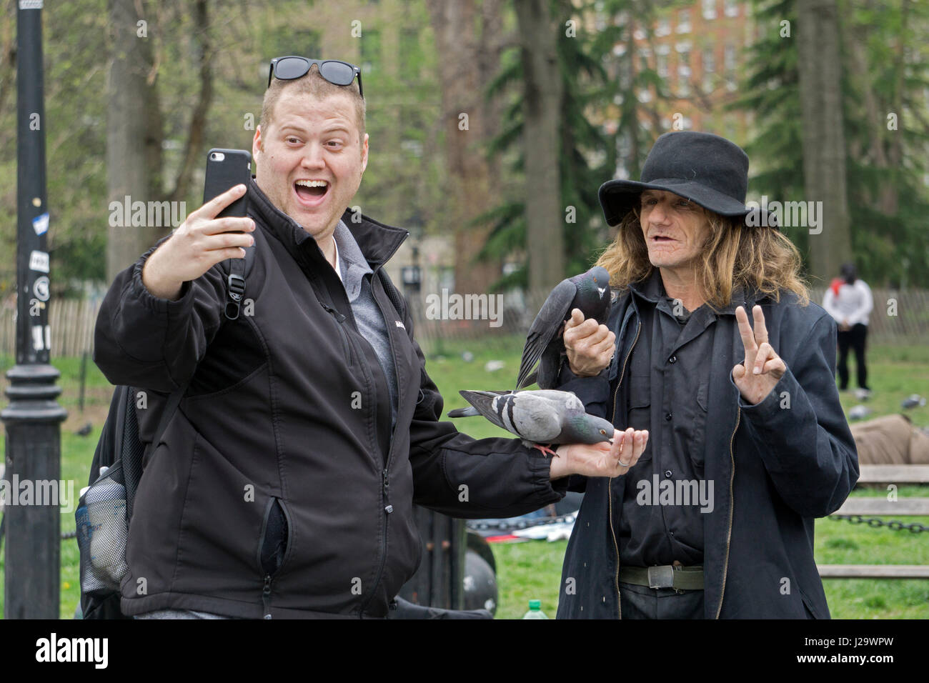 A smiling happy tourist takes a selfie with Larry the Birdman in ...