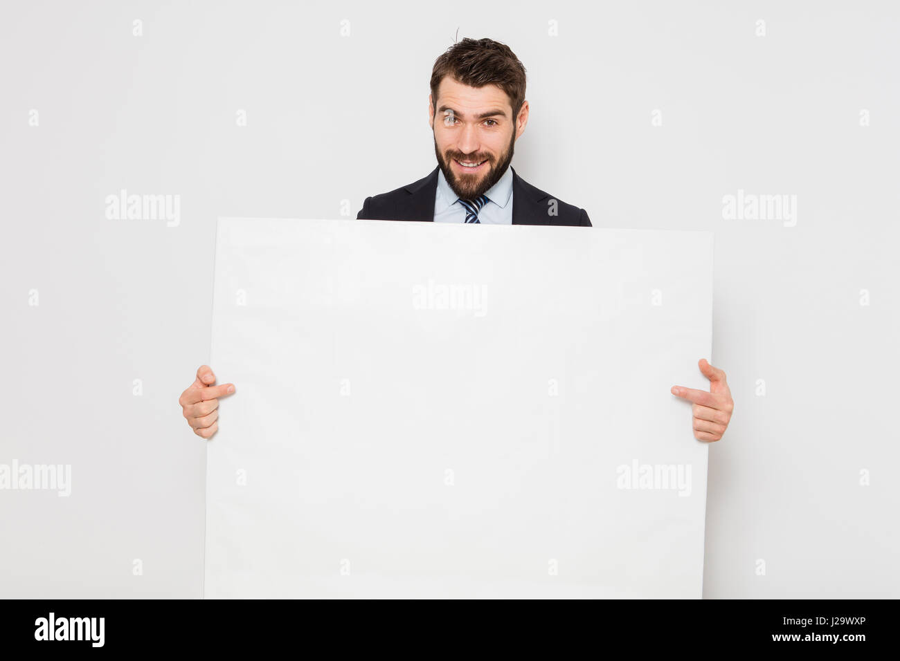 young elegant businessman with white empty panel on white Stock Photo ...