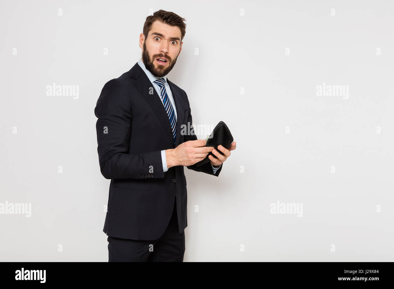 elegant man in suit standing and checking his empty wallet, on white ...