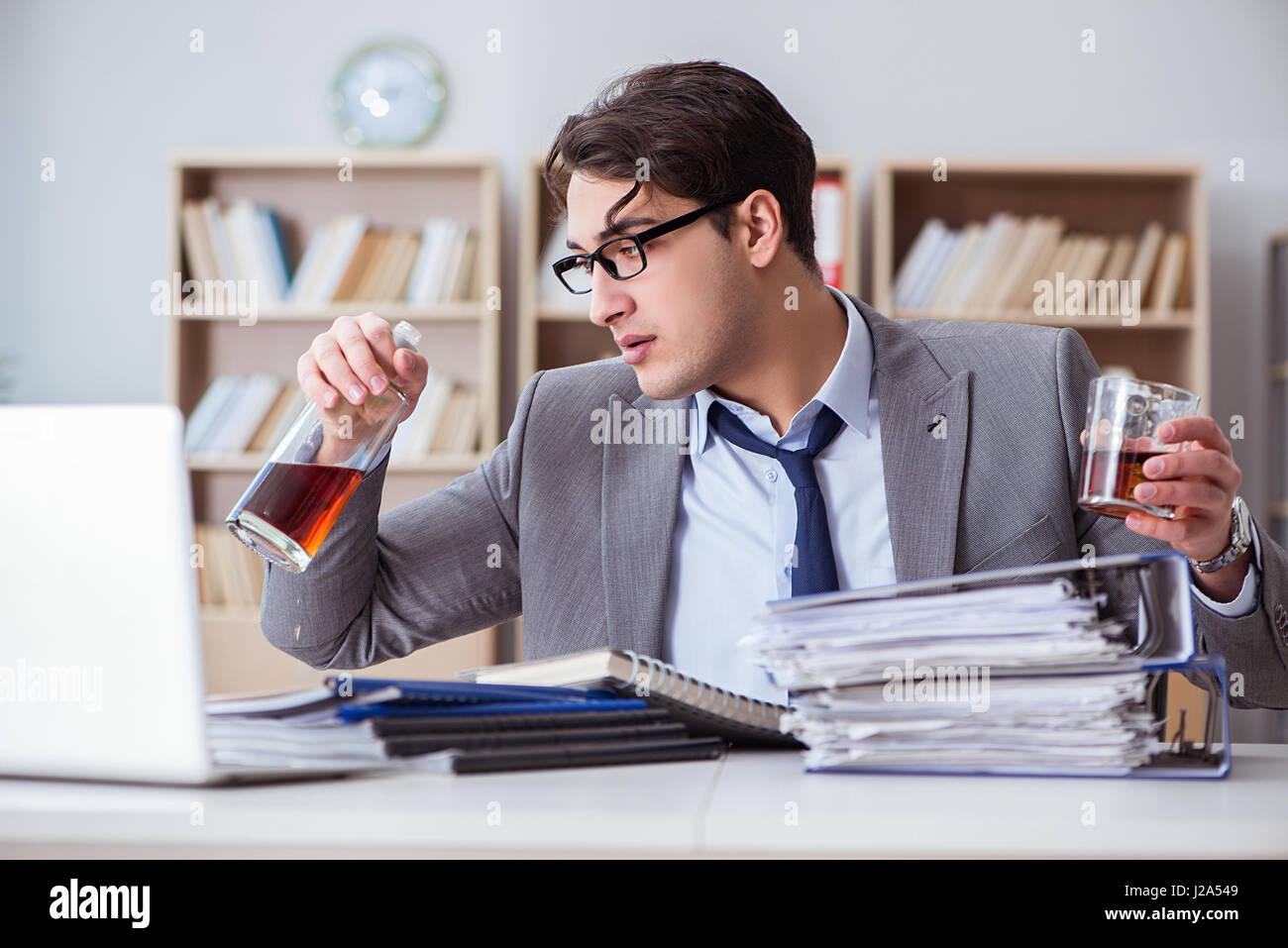 Businessman drinking in the office Stock Photo - Alamy