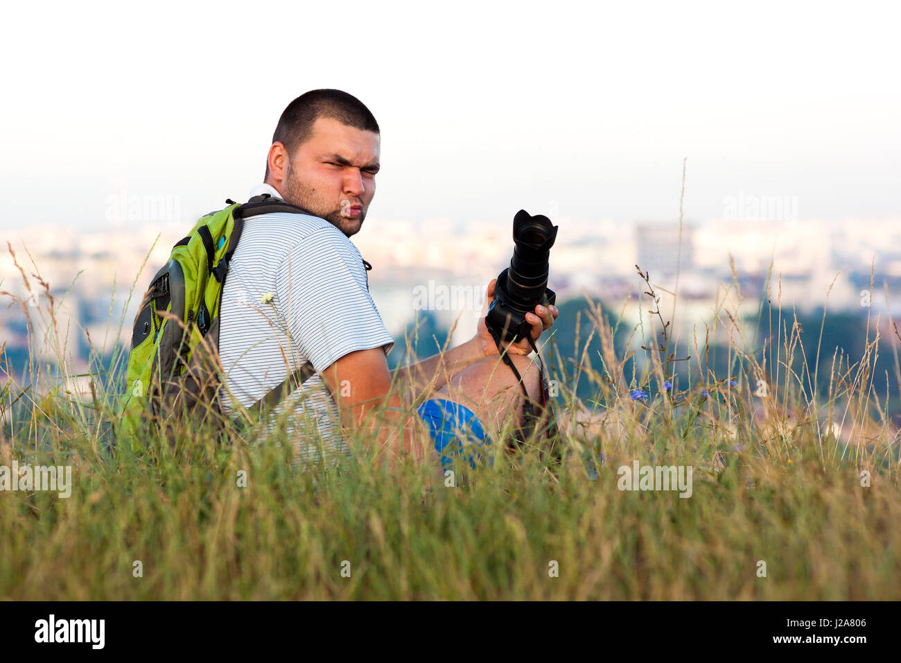 Angry photographer sitting in grass in summer with a camera Stock Photo ...