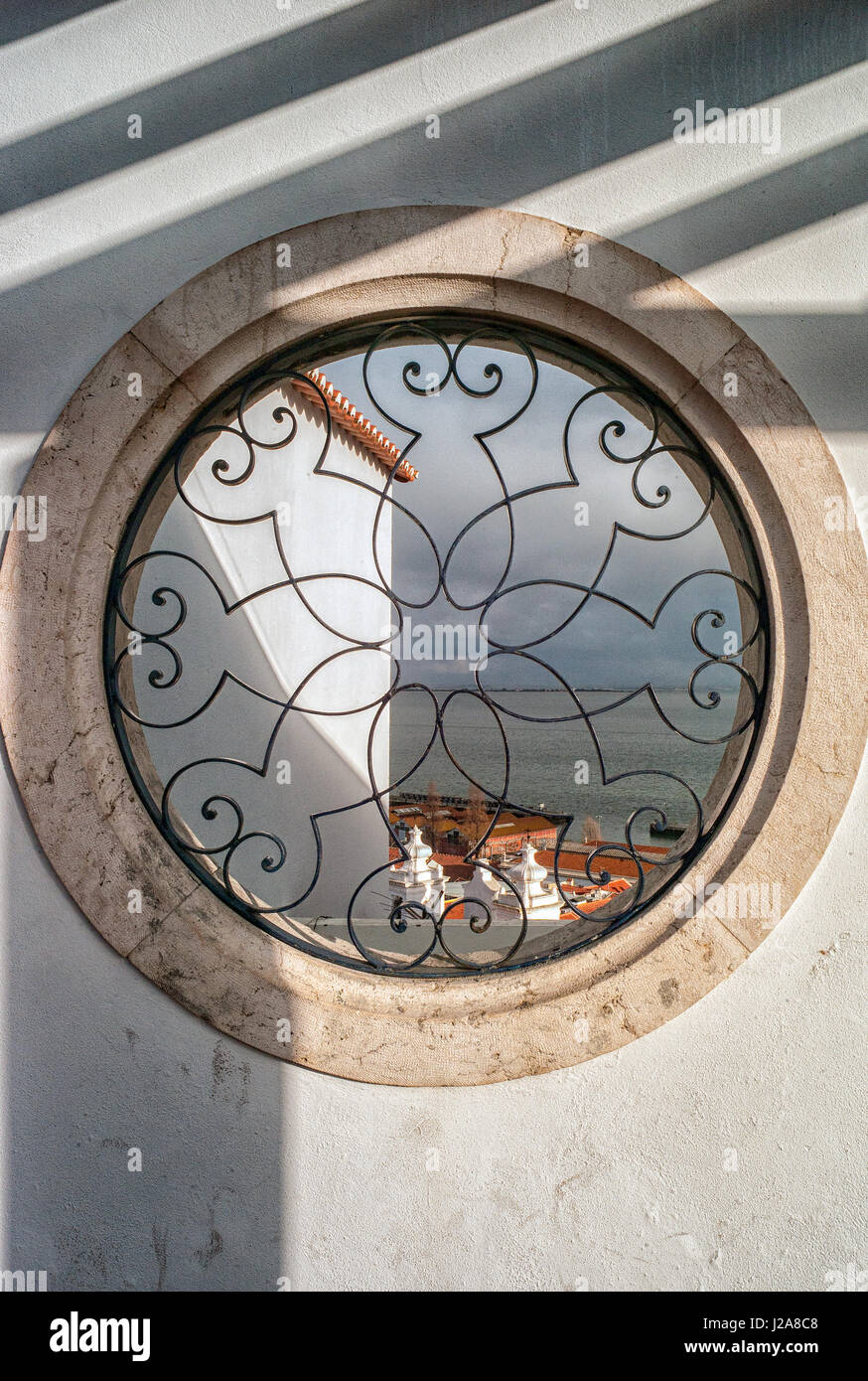 Architectural window in a wall in Lisbon, Portugal, with a view of ...