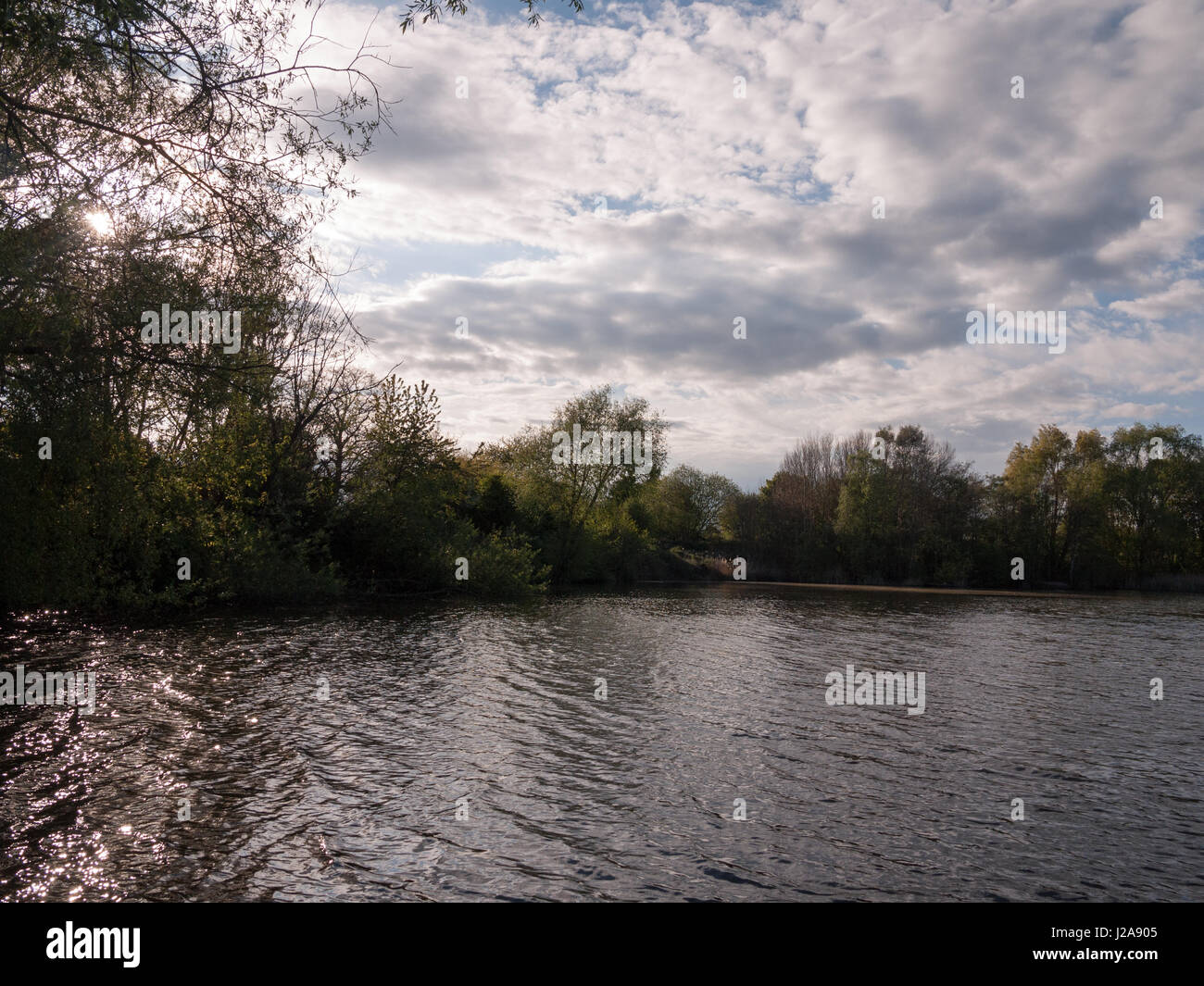 sunset over a lake in spring with moving waves ripples and clouds with ...