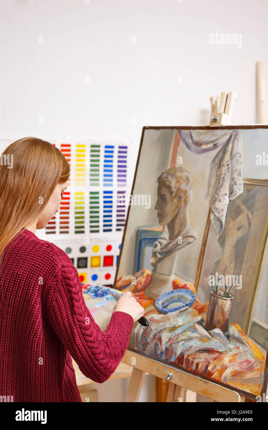 Classes in art school. The girl draws a large picture of oil paints ...