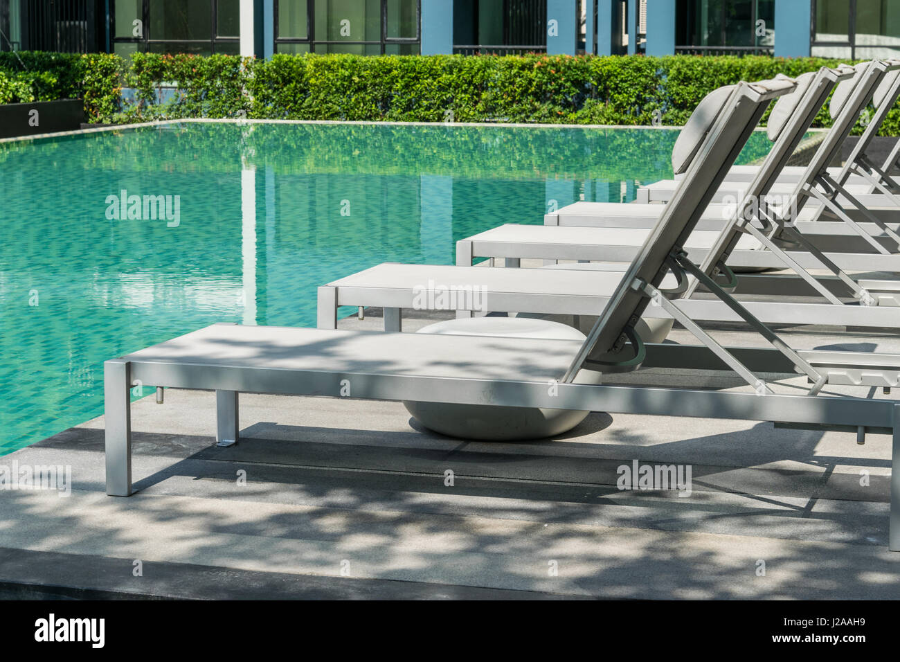 Swimming pool with beach chairs Stock Photo - Alamy