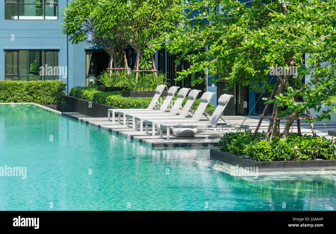 Swimming pool with beach chairs Stock Photo - Alamy