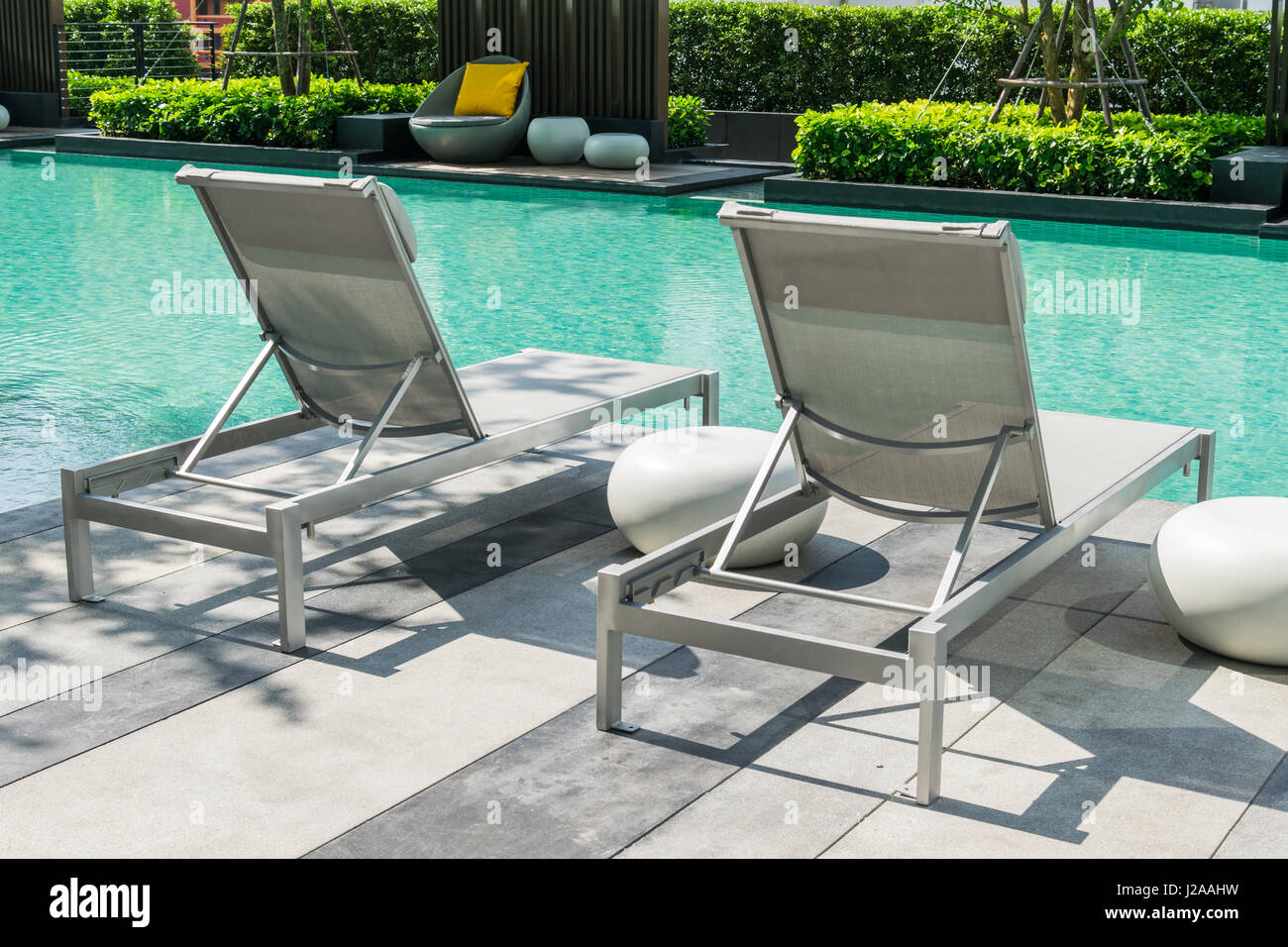 Swimming pool with beach chairs Stock Photo - Alamy