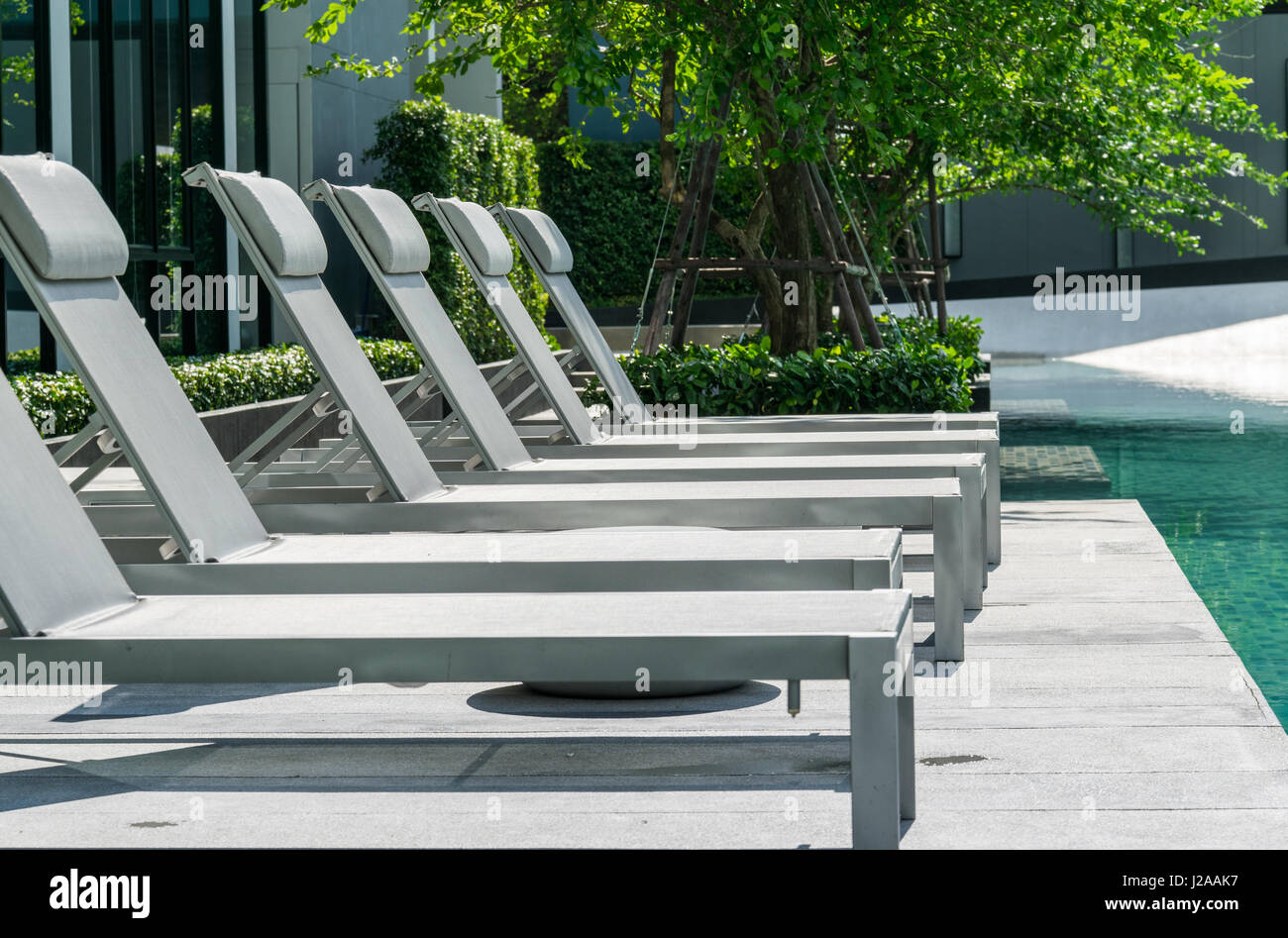 Swimming pool with beach chairs Stock Photo - Alamy
