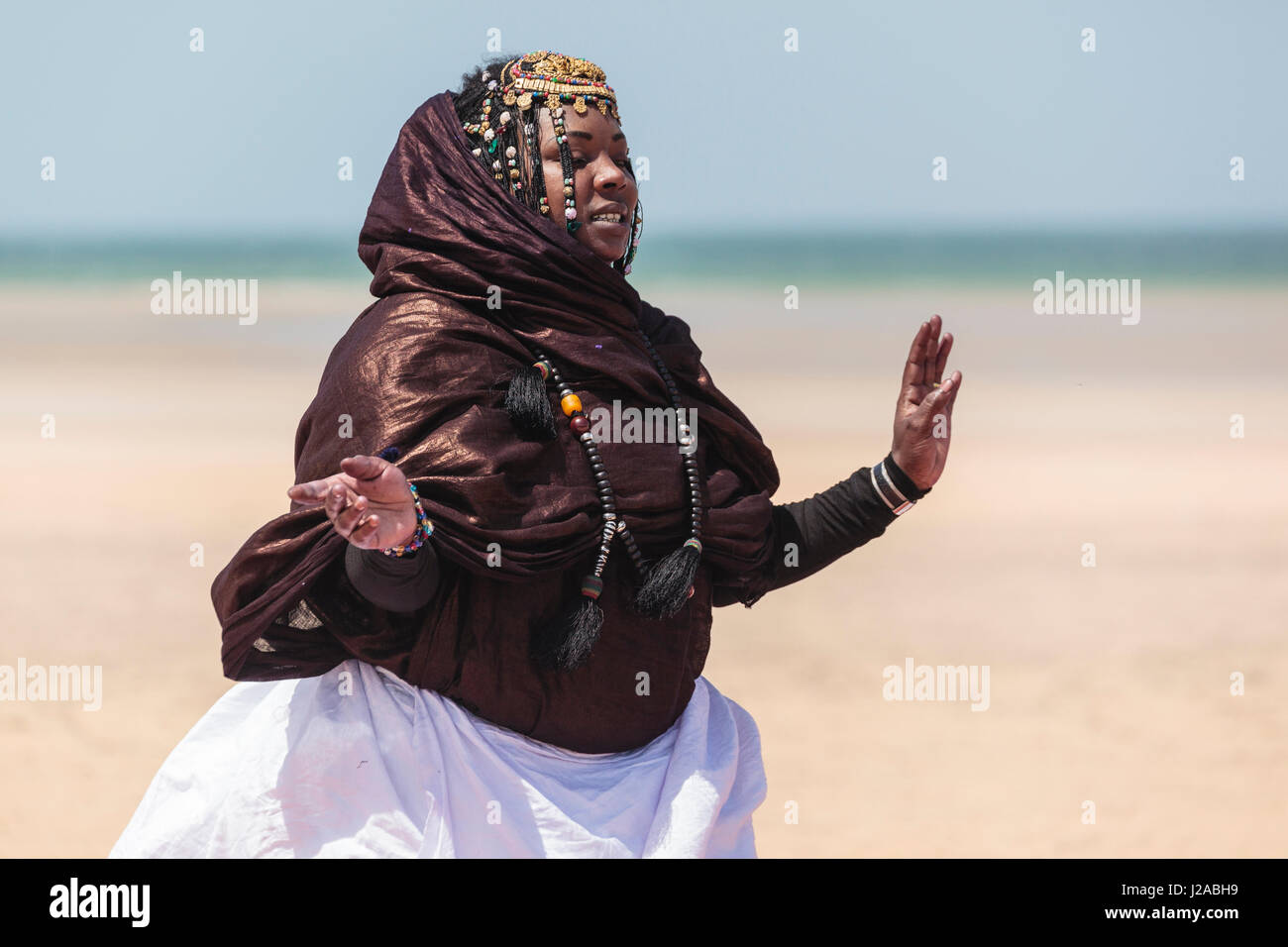 Africa, Western Sahara, Dakhla. Woman in tradition dress performing a ...
