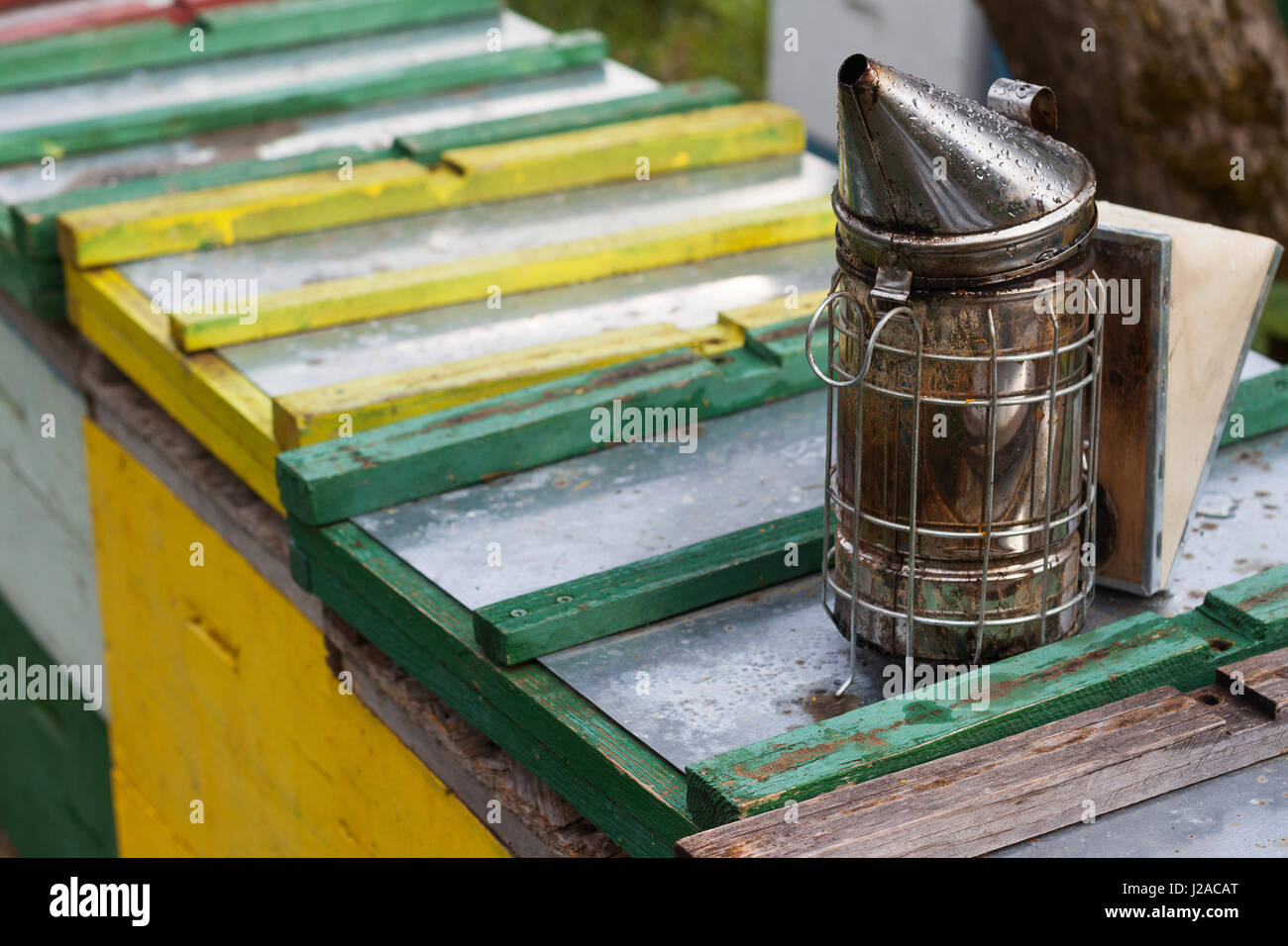 metallic bee smoker equipment on top of beehives boxes Stock Photo - Alamy