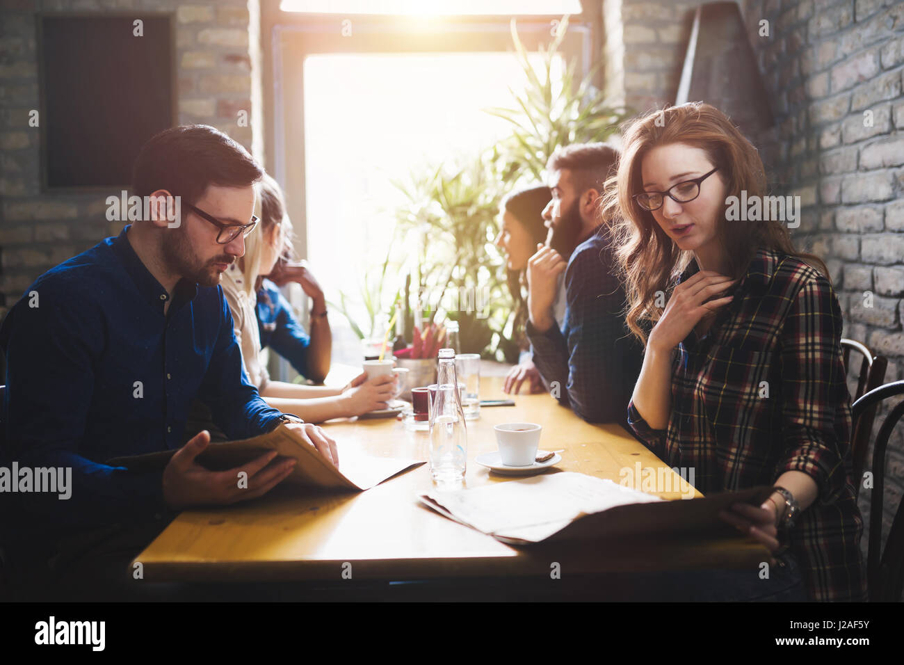 Happy colleagues from work socializing in restaurant and eating ...