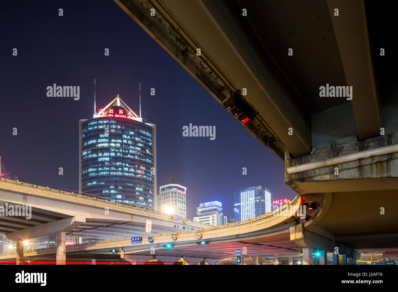 China, Beijing, Highway overpass and glowing steel and glass office ...