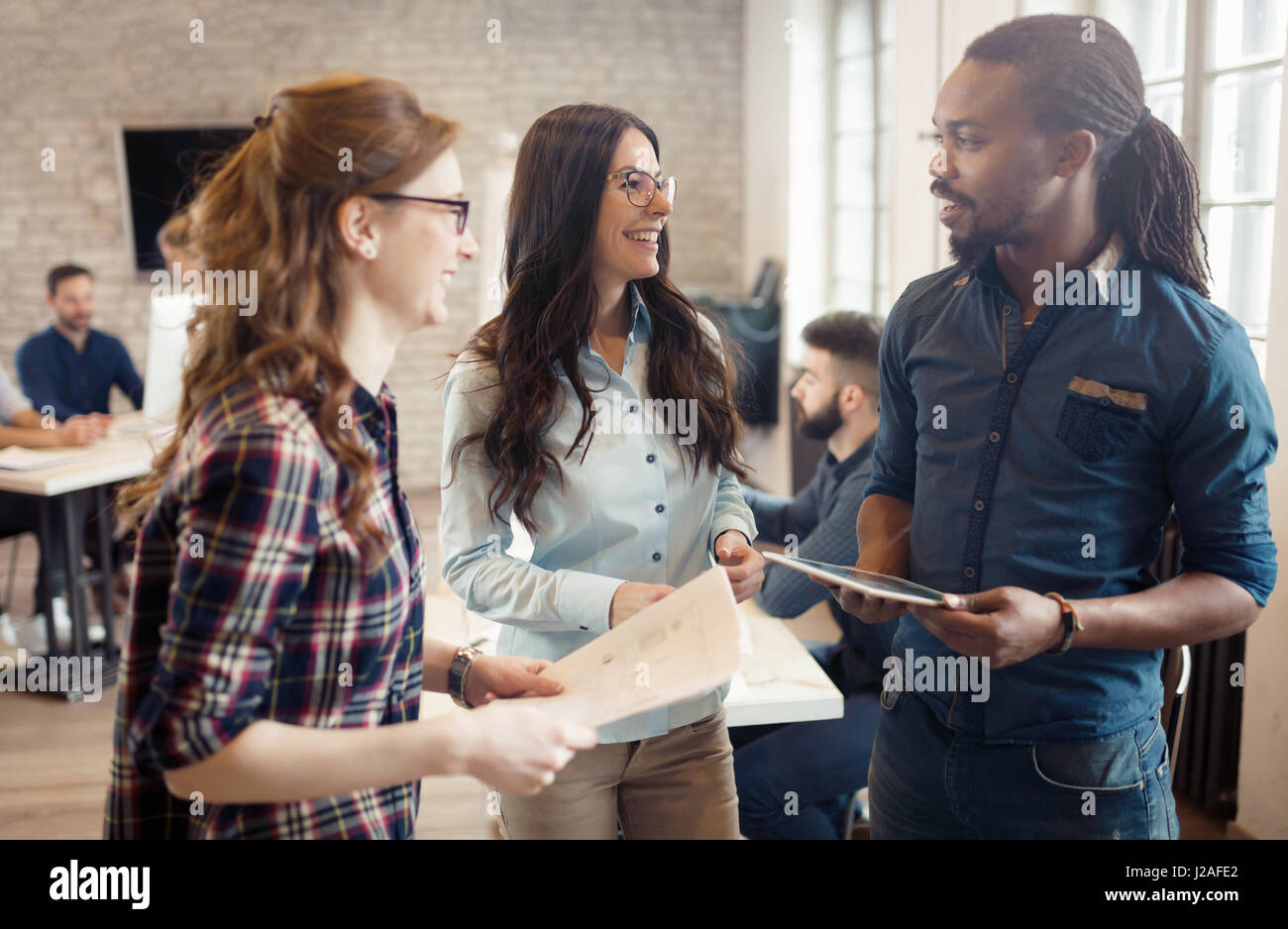 Company coworkers working in office and sharing new ideas Stock Photo ...