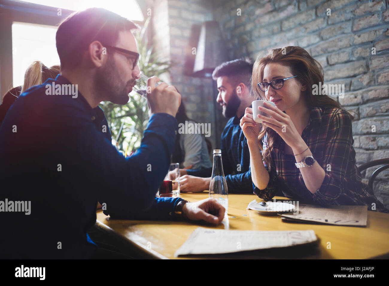 Happy colleagues from work socializing in restaurant and eating ...