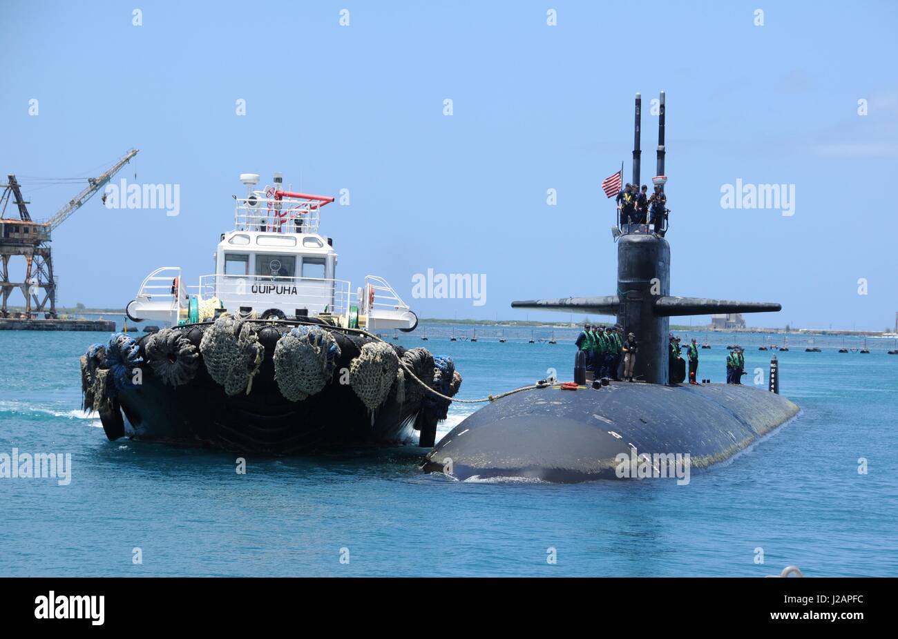 A tug boat tows the U.S. Navy Los Angeles-class fast-attack submarine ...