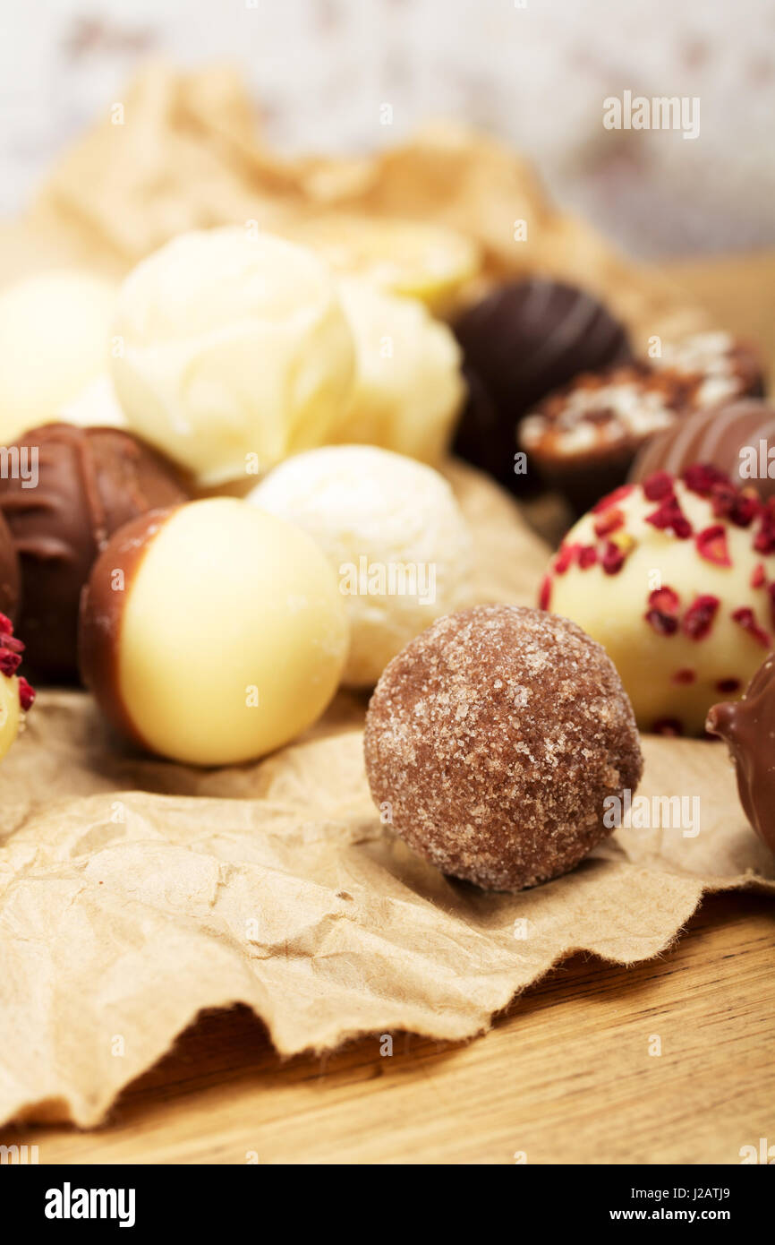Selection of delicious chocolates on rustic background Stock Photo - Alamy