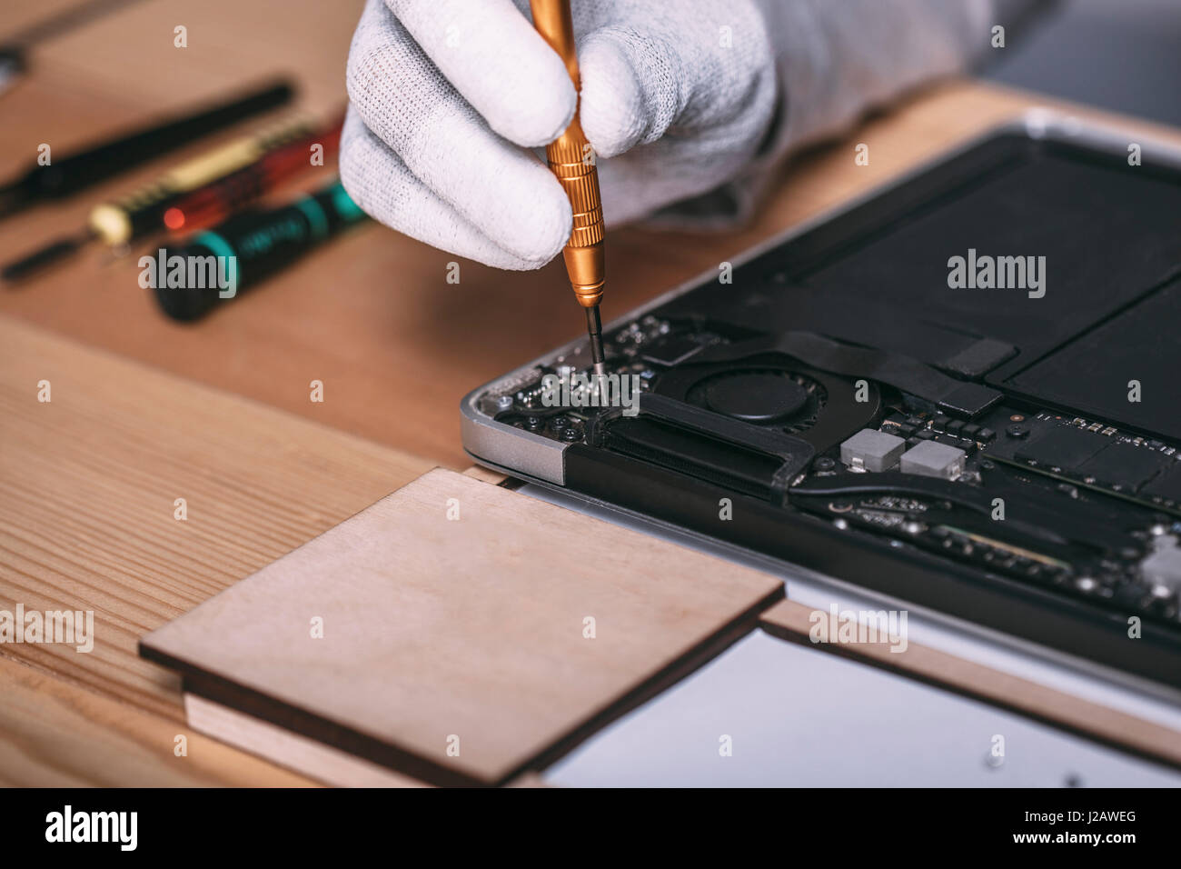 Detail image of male technician repairing digital tablet at electronics ...