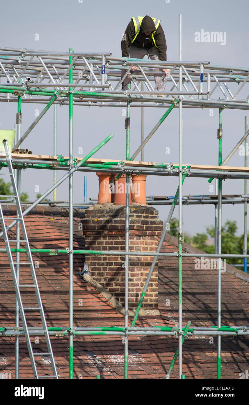 Scaffolding canopy being erected over domestic house roof in London ...